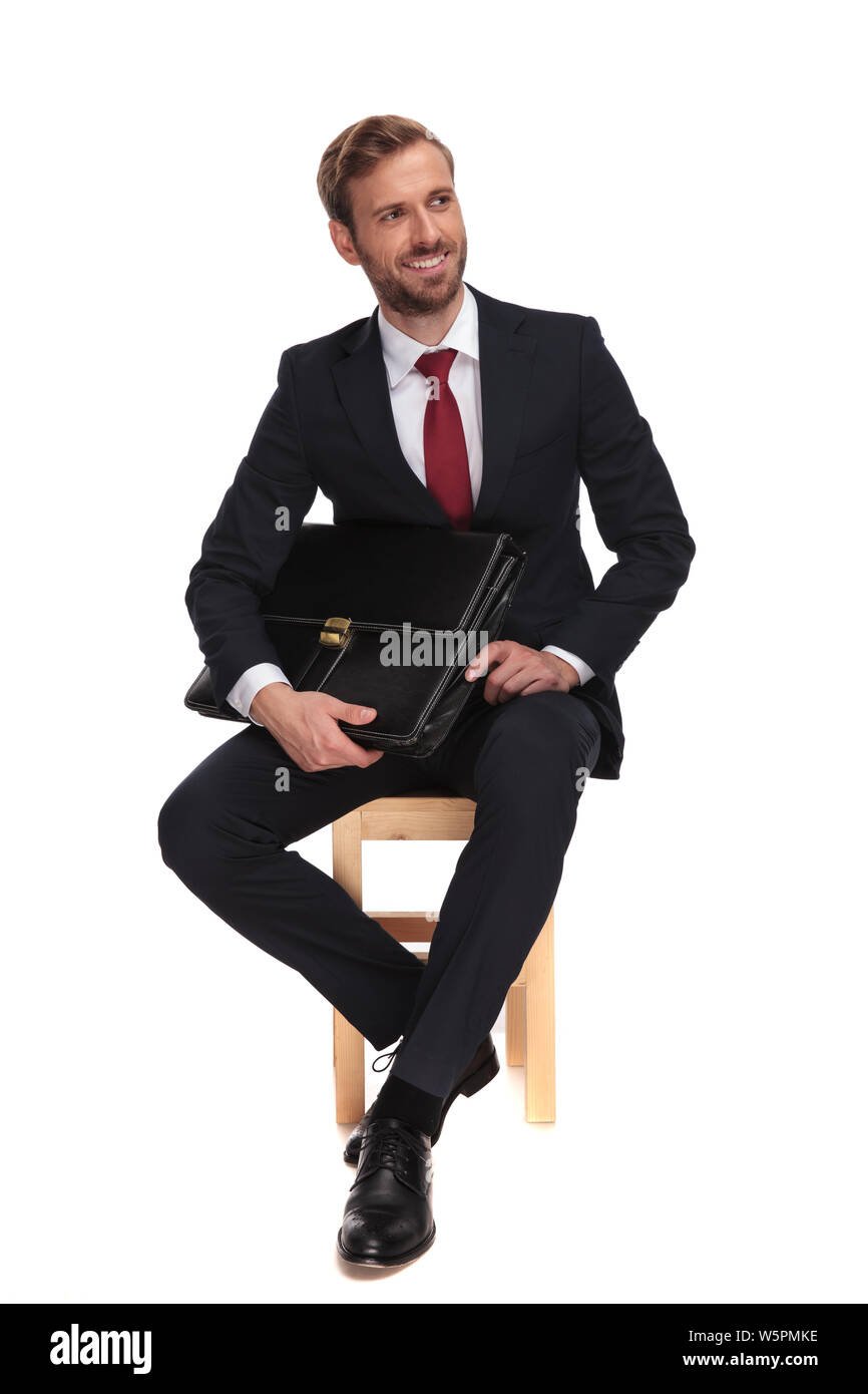 blonde businessman sitting on wooden stool on white background and ...