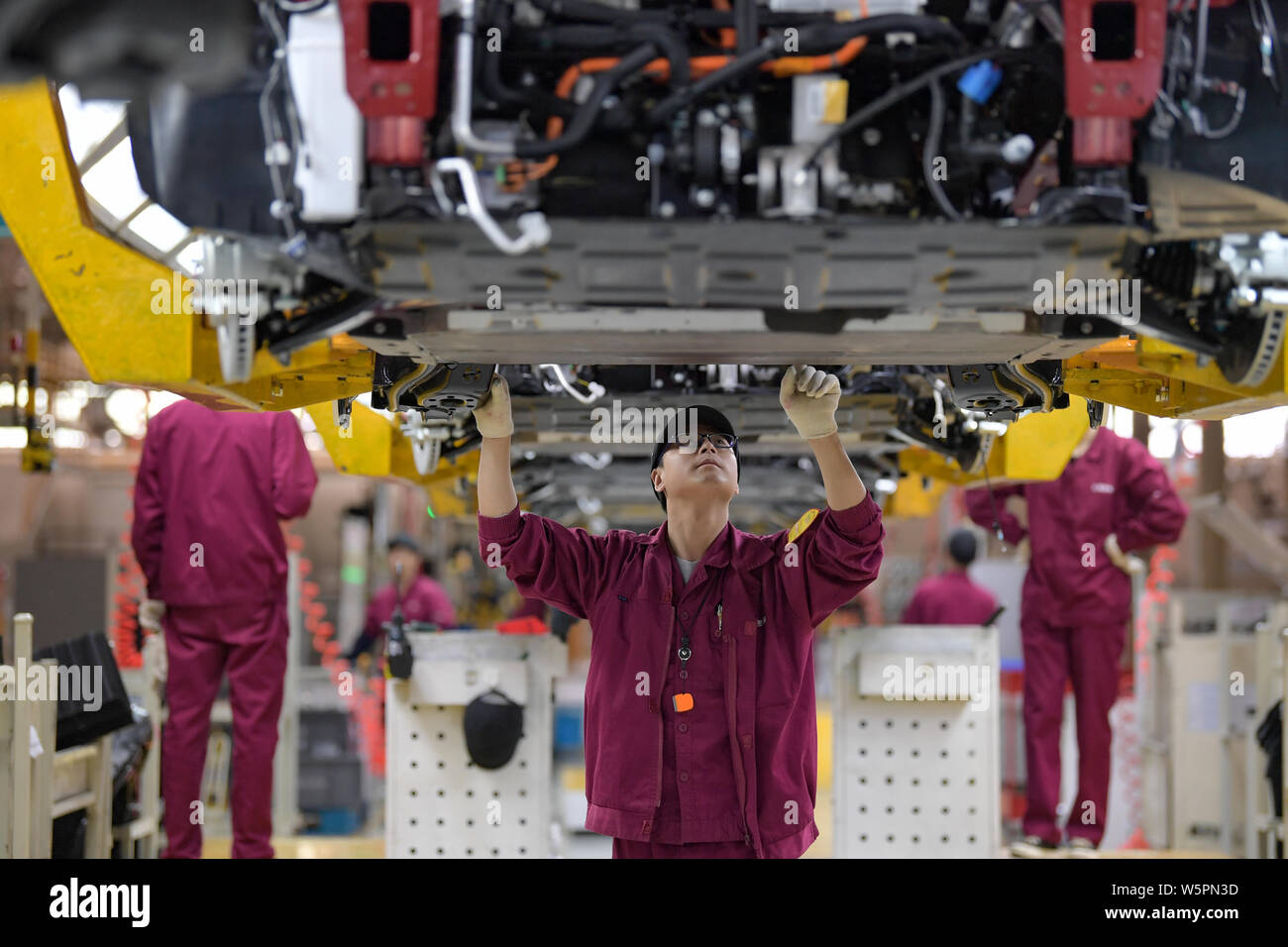Chinese workers assemble vehicles on the assembly line at the auto ...