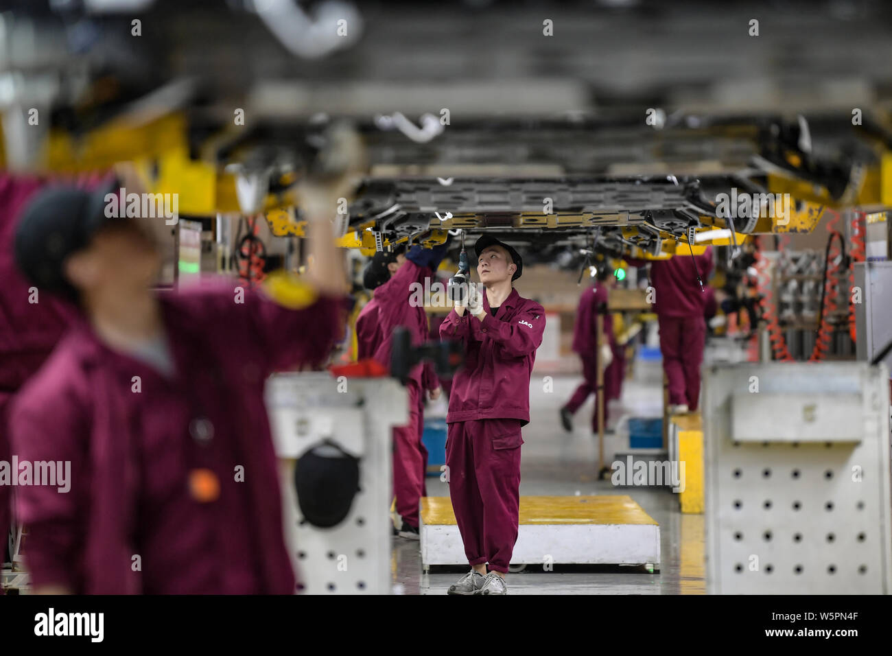 Chinese workers assemble vehicles on the assembly line at the auto ...