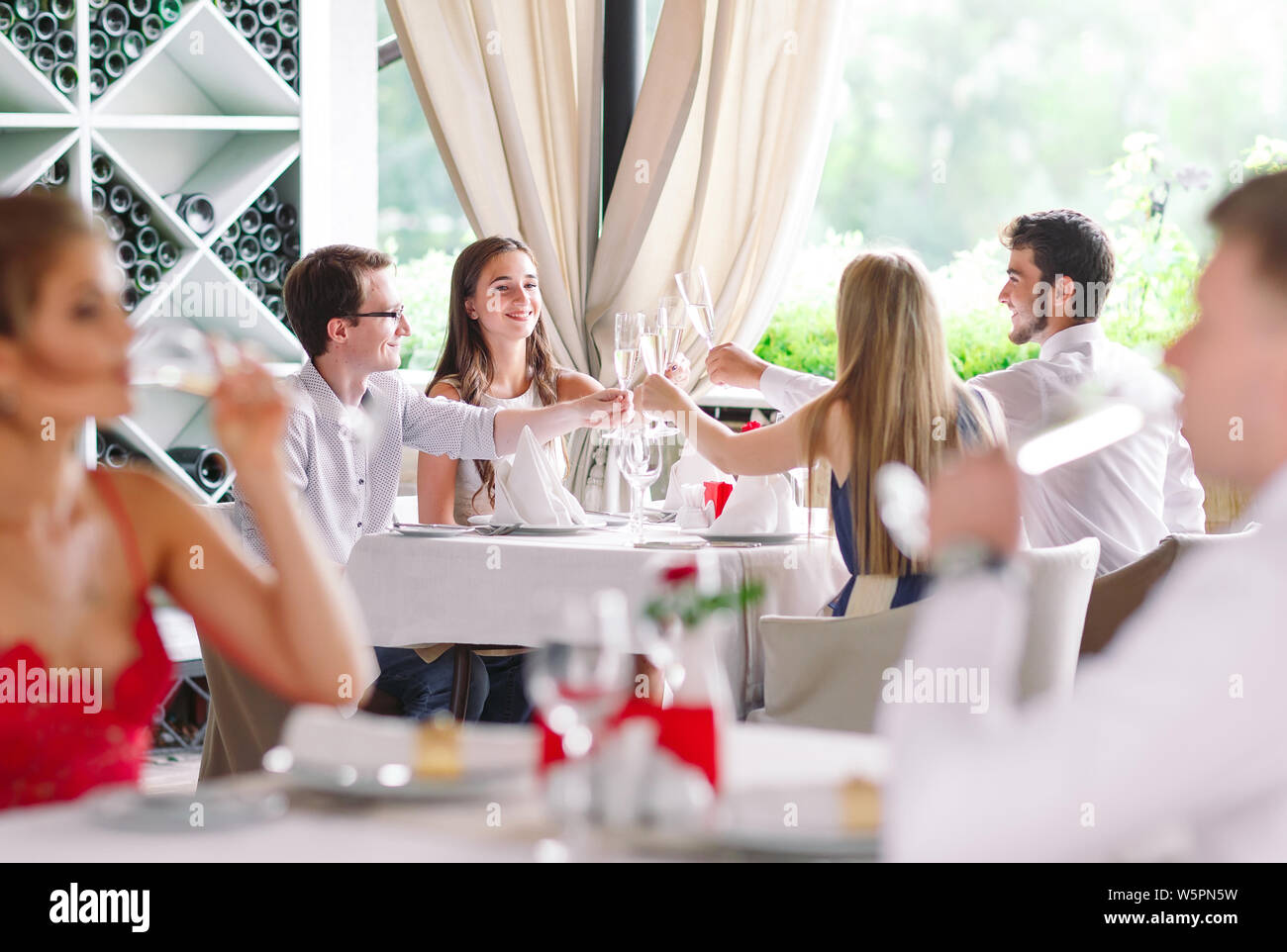 Friends in the restaurant having a toast Stock Photo - Alamy