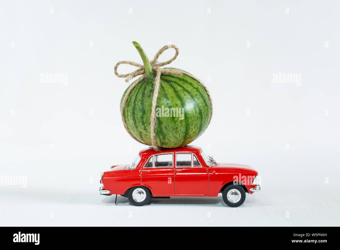 Red vintage toy car with small watermelon on the roof. Isolated image ...