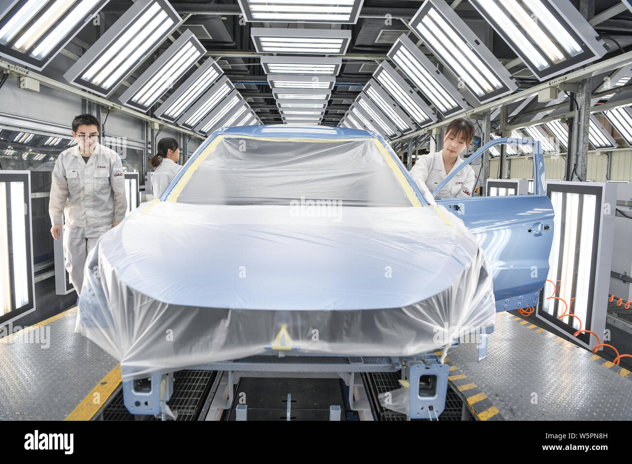 Chinese workers assemble vehicles on the assembly line at the auto ...