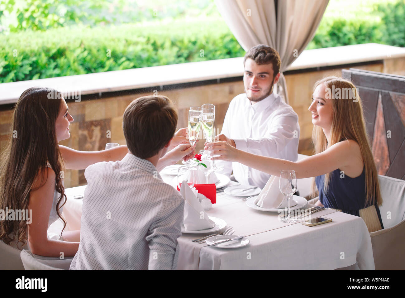 Friends in the restaurant having a toast Stock Photo - Alamy