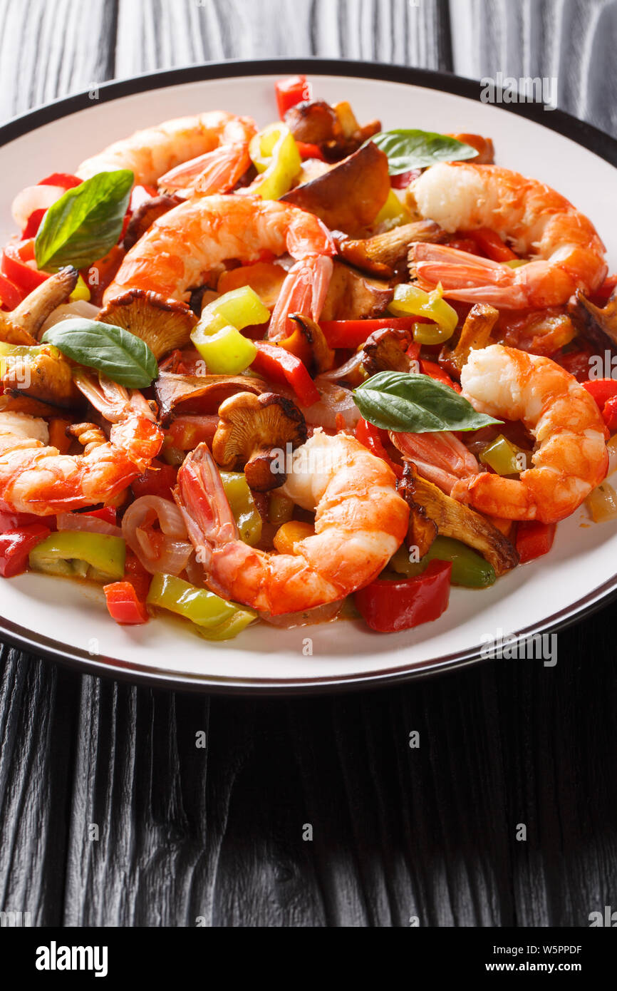 Delicious king prawns with mushrooms and vegetables close-up on a plate ...