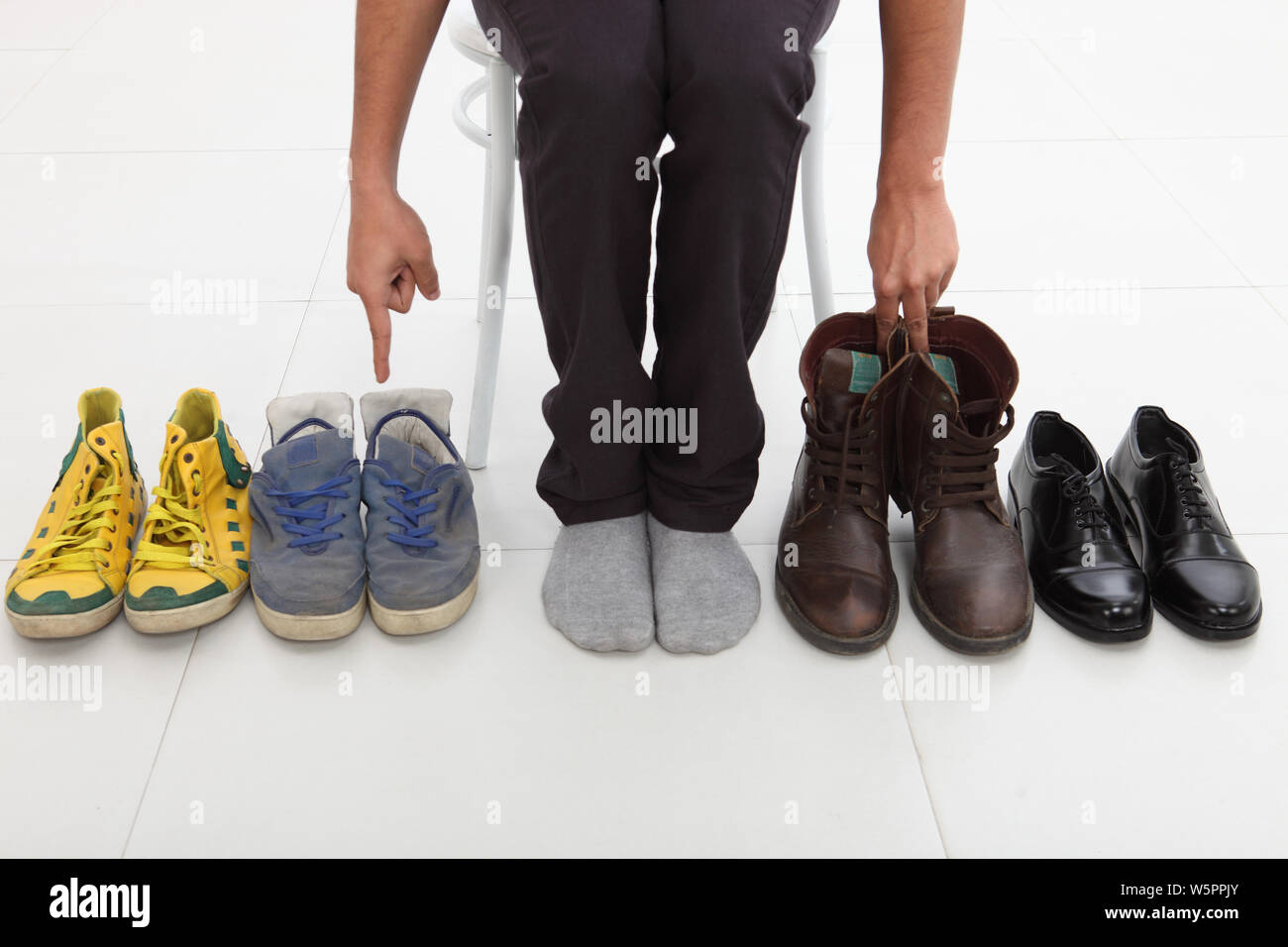 Low section view of a man deciding which shoes to wear Stock Photo - Alamy