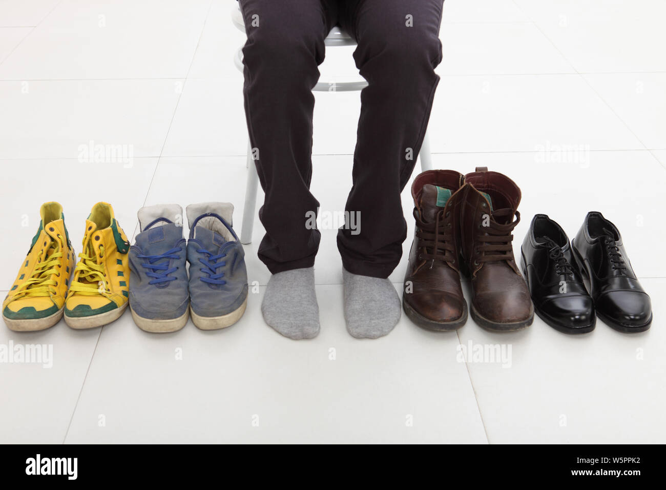 Low section view of a man deciding which shoes to wear Stock Photo - Alamy