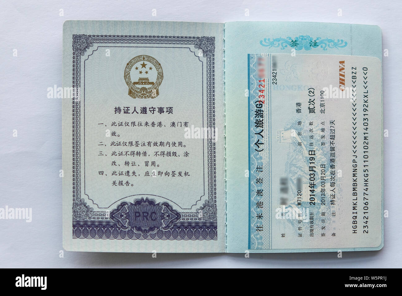 A police officer shows the passport-shaped travel pass for use between ...