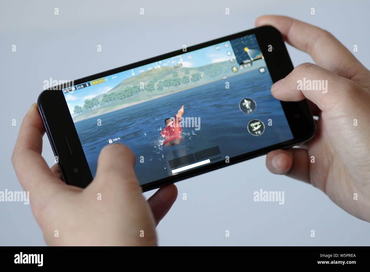 --FILE--A Chinese mobile game player plays Tencent's multiplayer online ...