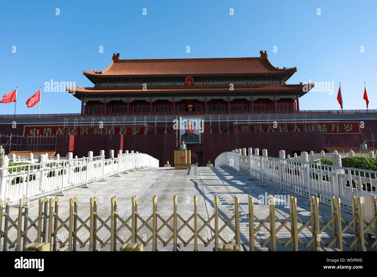 Chinese paramilitary policemen stand guard in front of scaffoldings ...