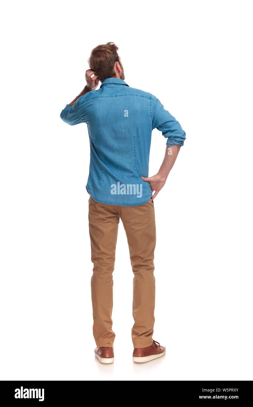 back view of a young casual man scratching his head on white background ...