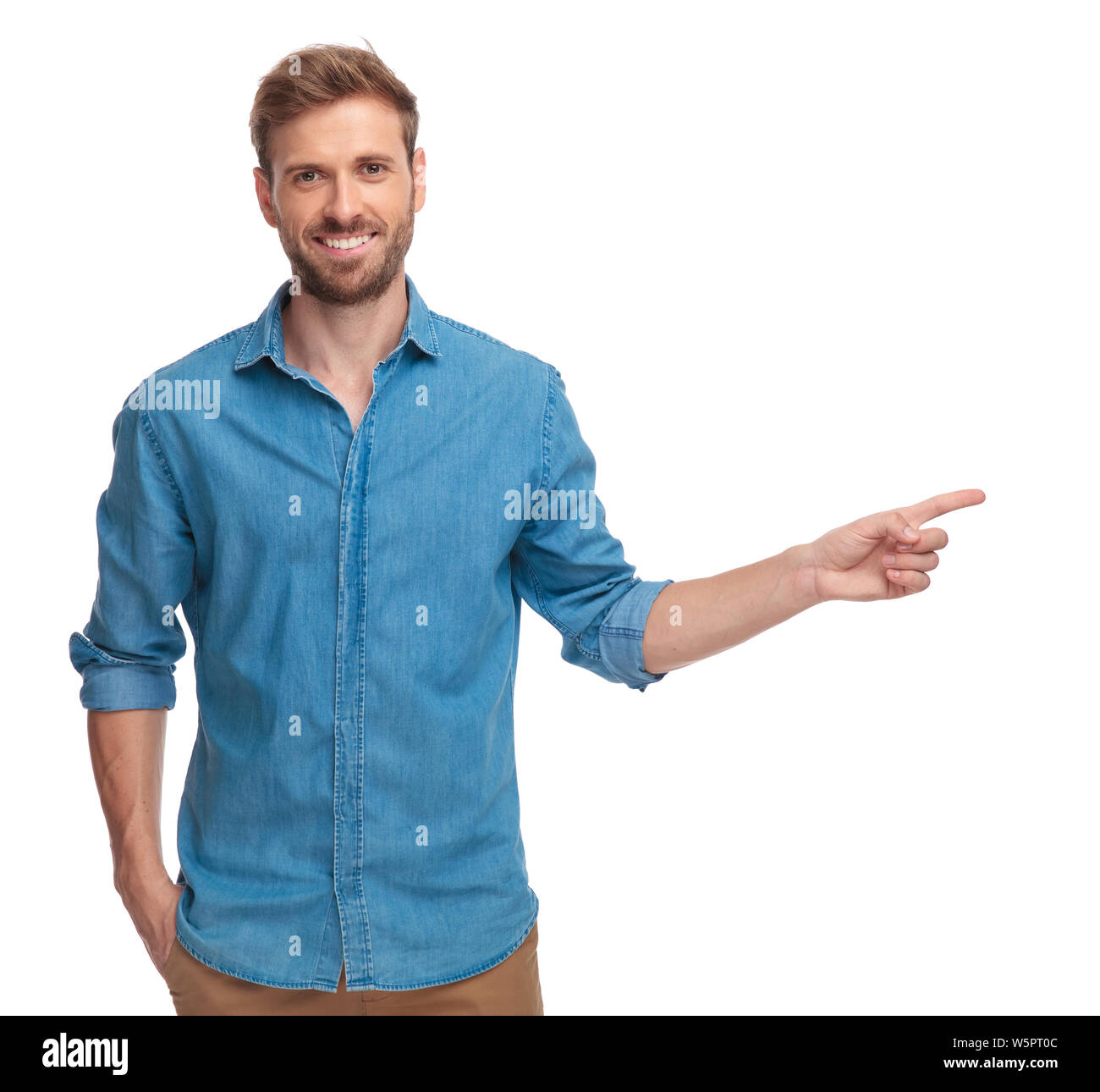 smiling young man is pointing to side on white background Stock Photo ...