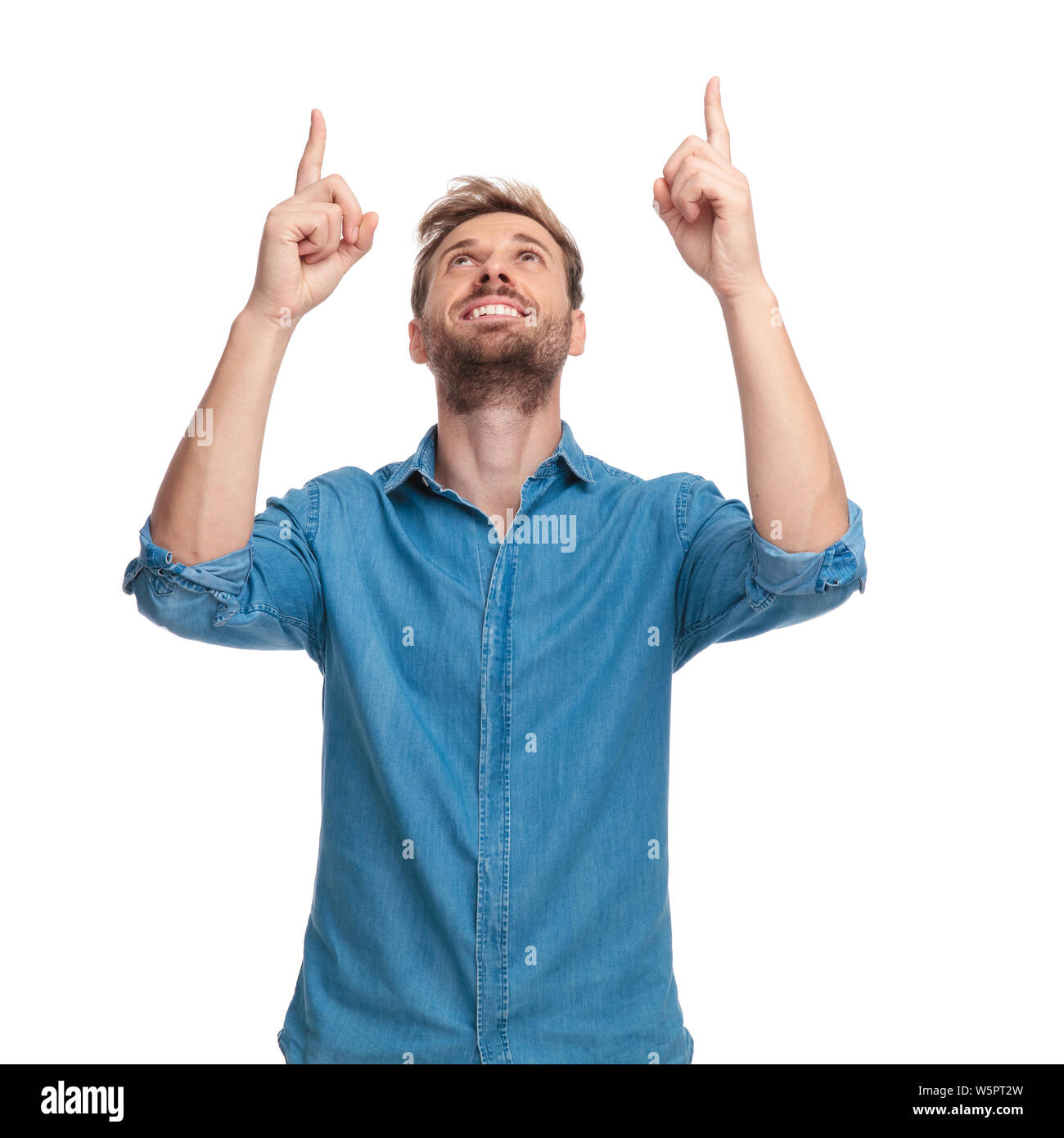 smiling casual man pointing fingers above his head at something on ...
