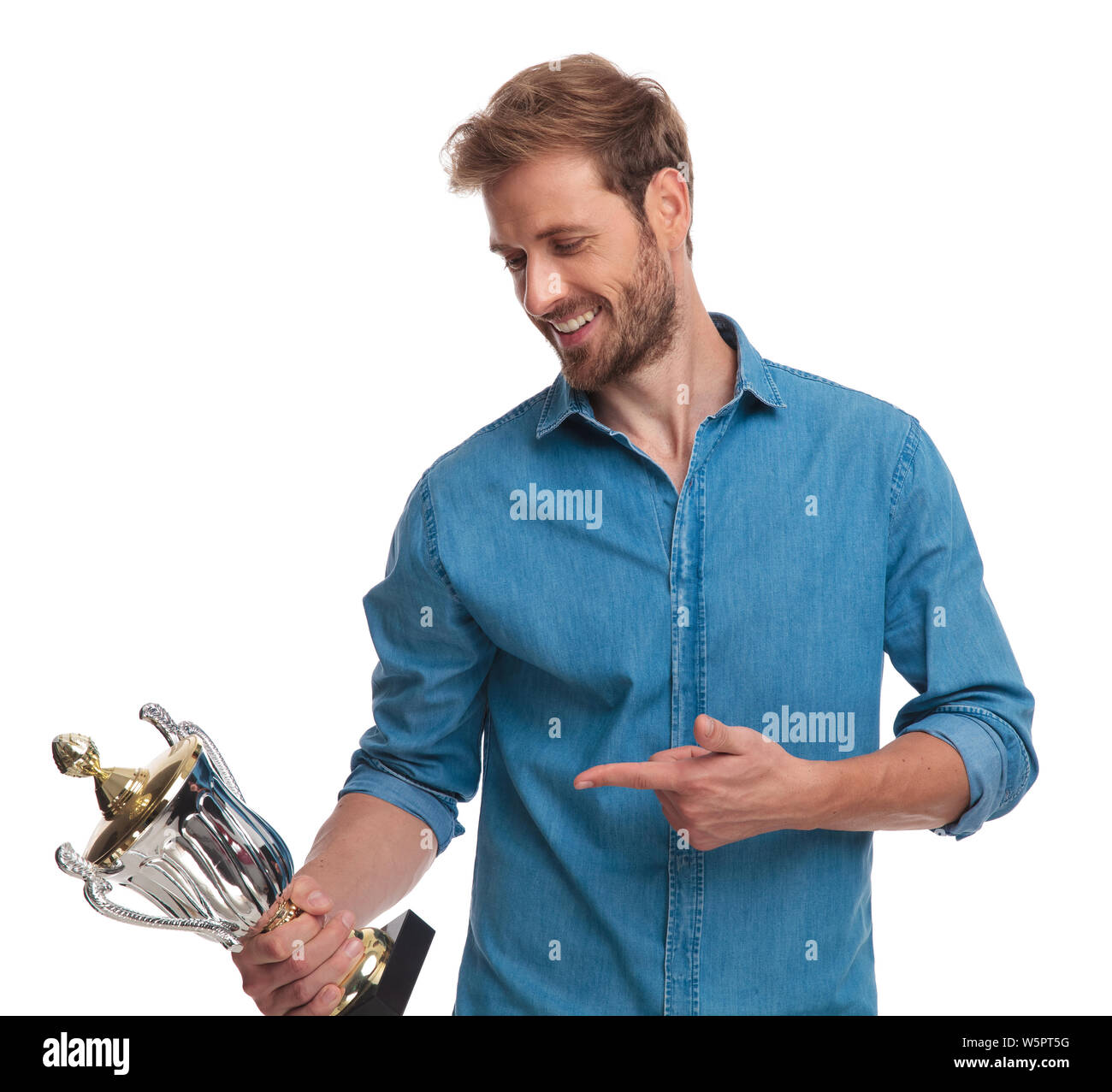 proud casual man pointing finger at his trophy on white background ...