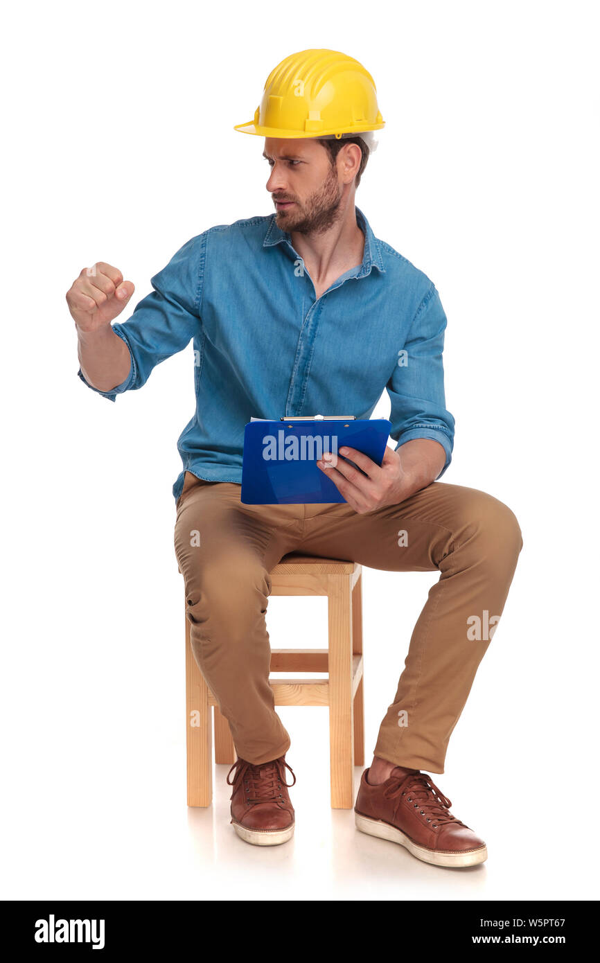 angry construction engineer thretening with fist up to side on white ...