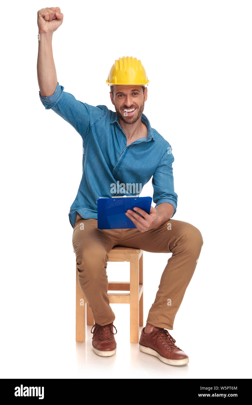 happy winning construction engineer with hand in the air celebrating ...