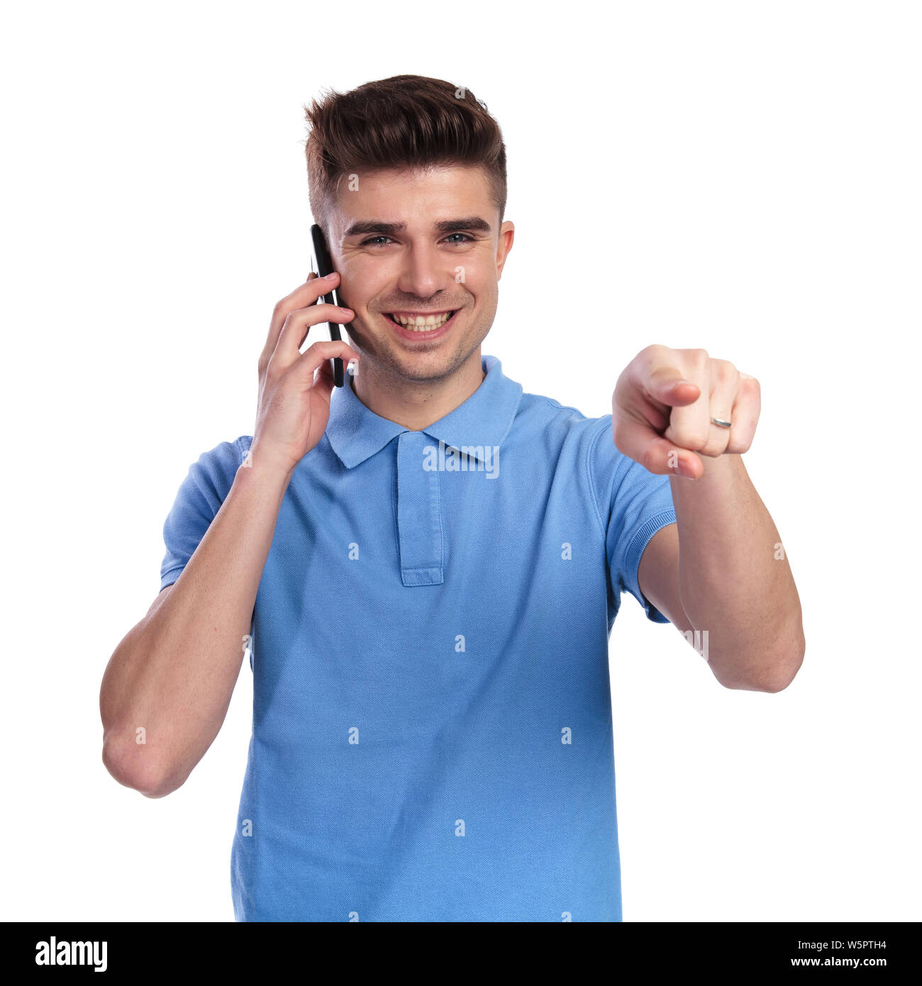 smiling casual man talking on the phone is pointing finger on white ...