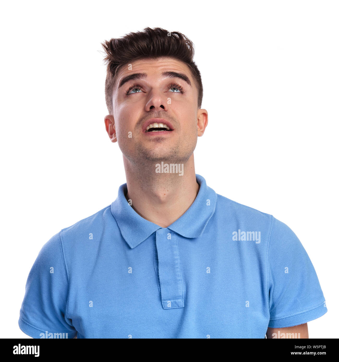 young casual man looks up at something on white background Stock Photo ...