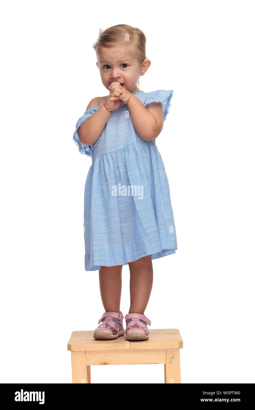 little cute baby girl is beig scared and looks very anxious while ...