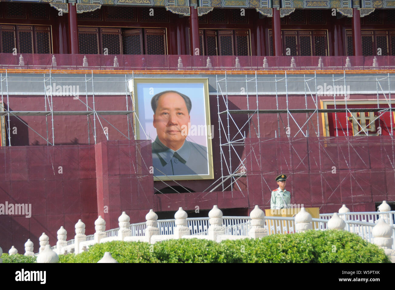 A Chinese paramilitary policeman stands guard in front of scaffoldings ...