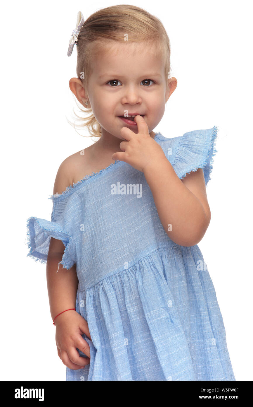 smiling little girl with finger in her mouth on white bakground Stock ...