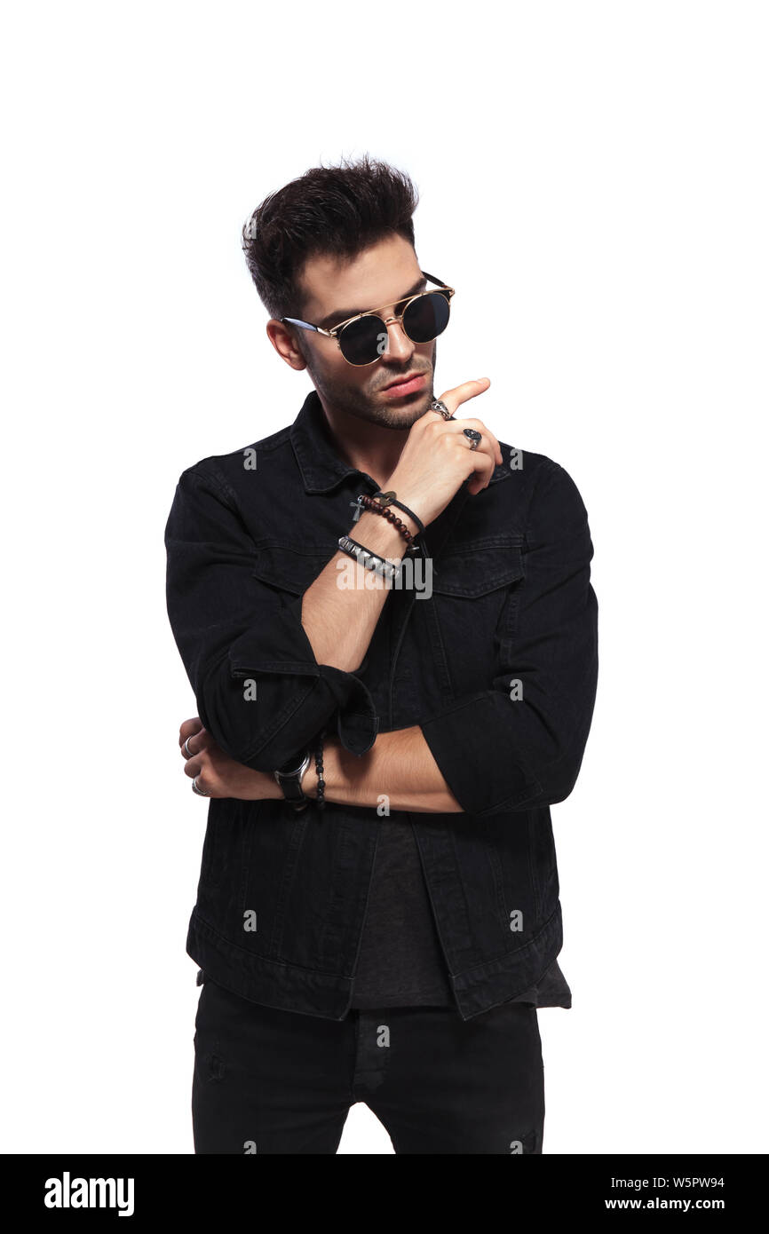 portrait of young casual man looking to side and thinking while ...