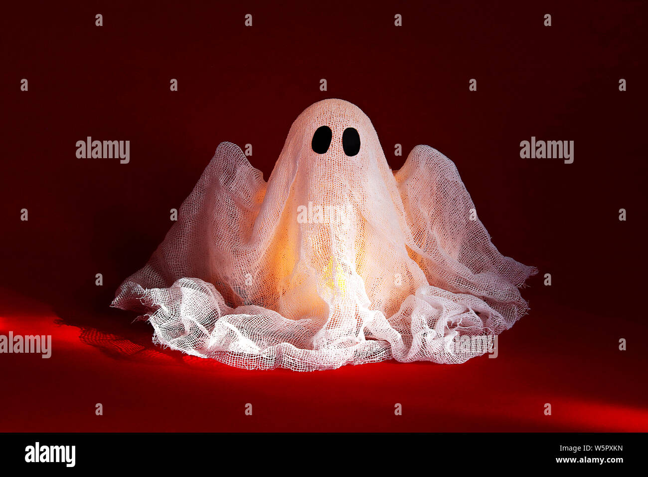 Halloween ghost of starch and gauze on orange background. Gift idea ...