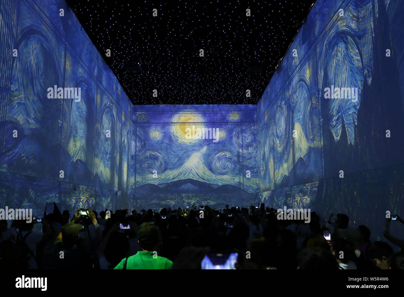 Visitors view or take pictures of a projection of art by Dutch post ...