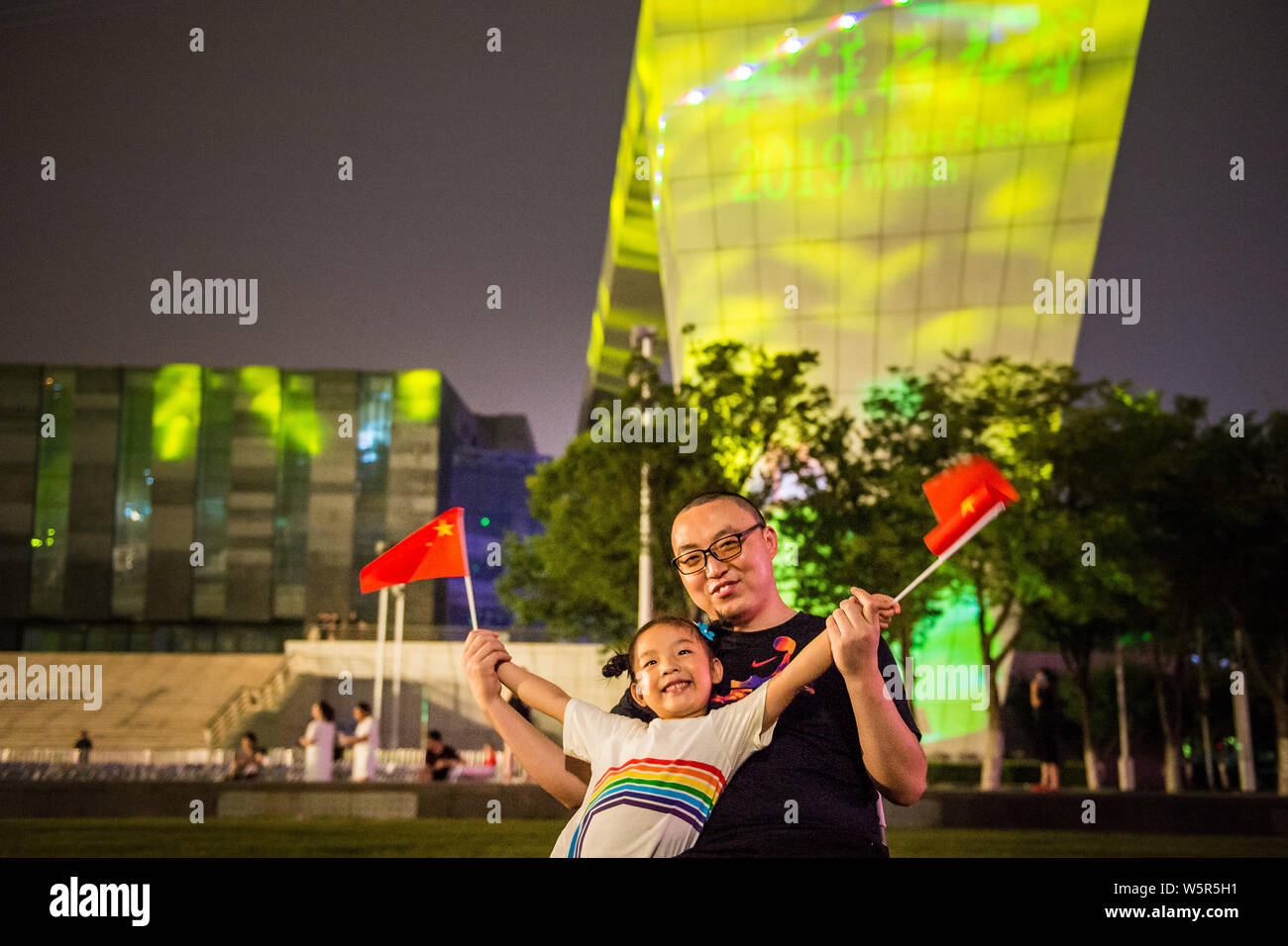 Local residents pose with Chinese national flags to mark the opening of ...