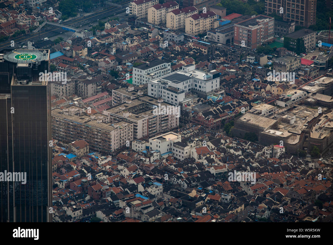 Residential houses in longtang are embraced by skyscrapers and high ...