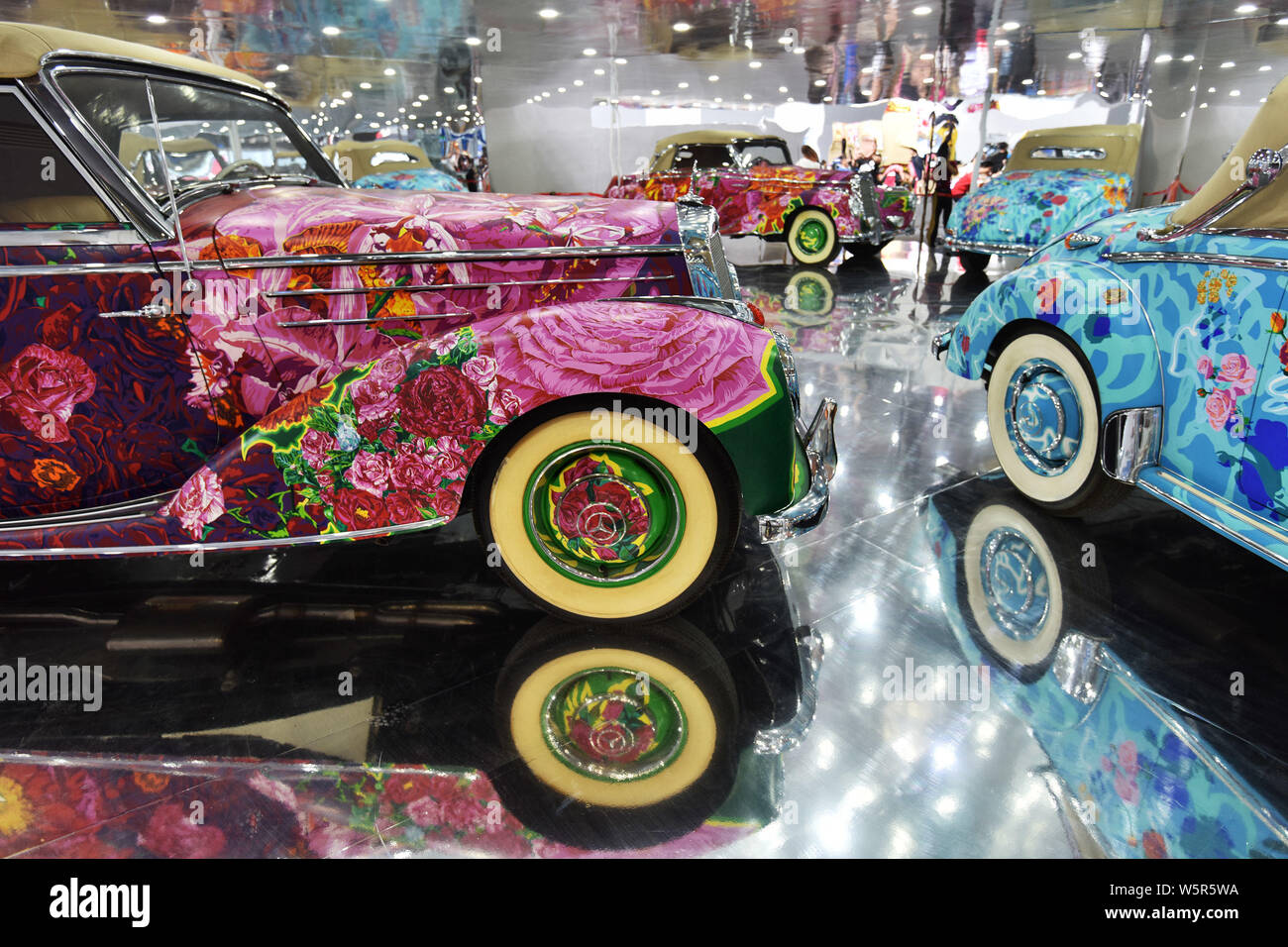 Vintage vehicles covered with colorful oil painting images are ...