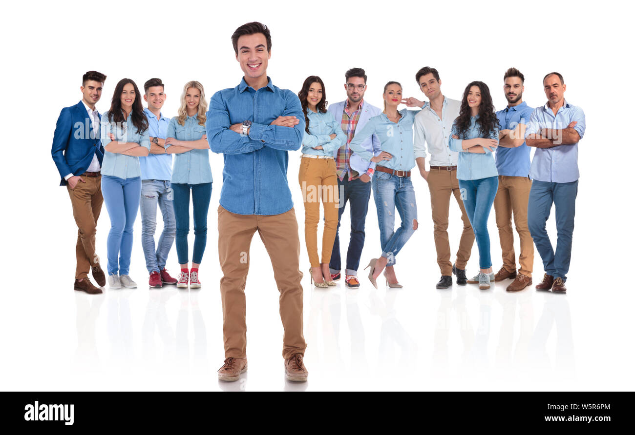 happy and confident team leader standing with arms crossed in front of ...