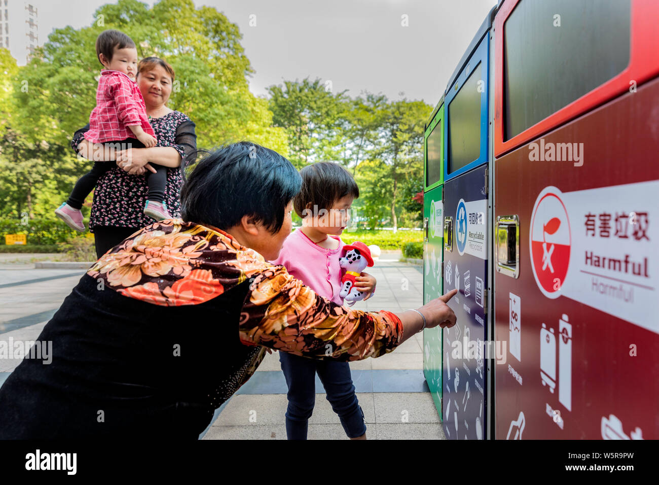 A Chinese elderly woman teaches her granddaughter to learn garbage ...