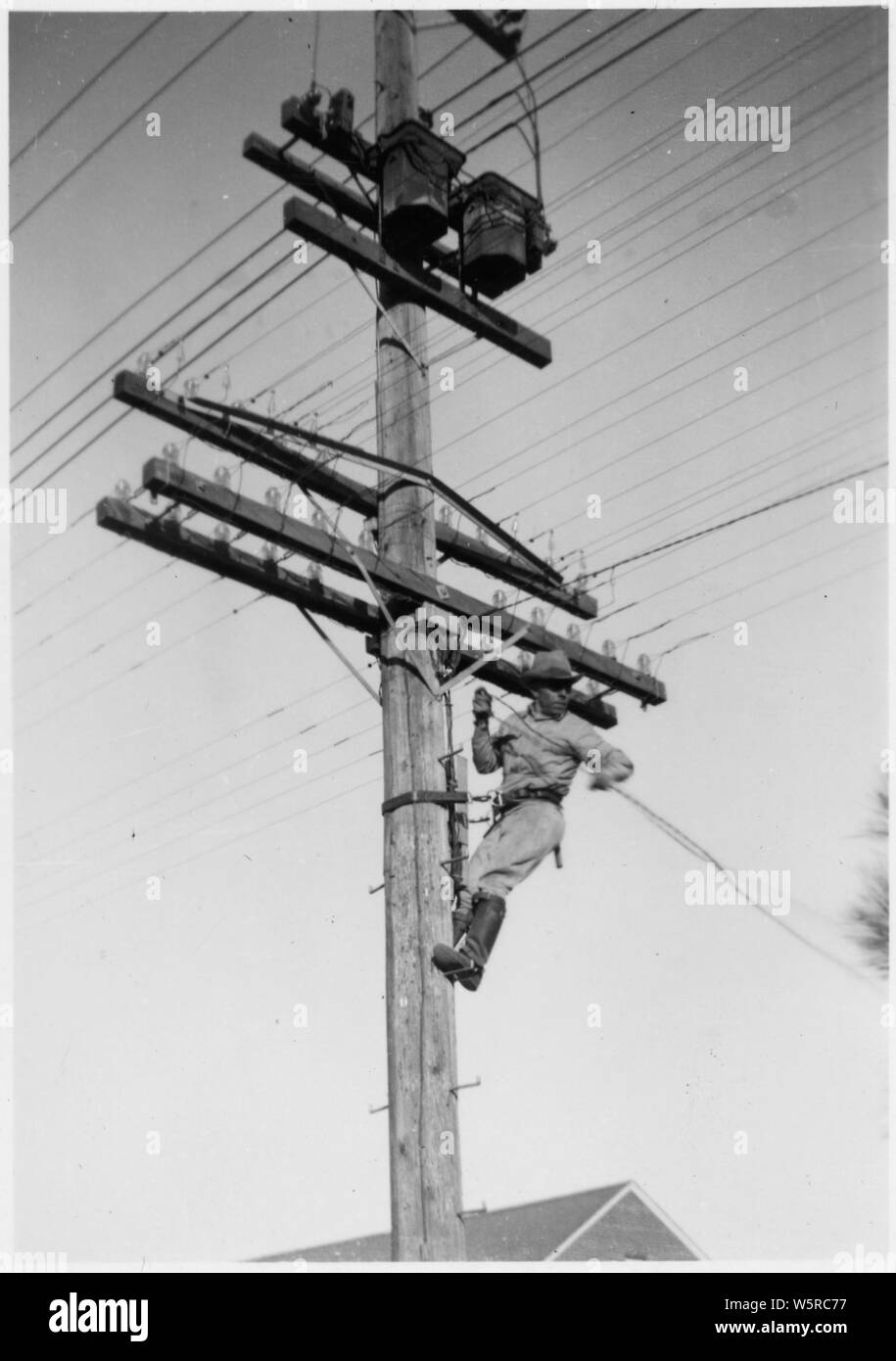 Man on telephone pole works on changing the lines Stock Photo - Alamy