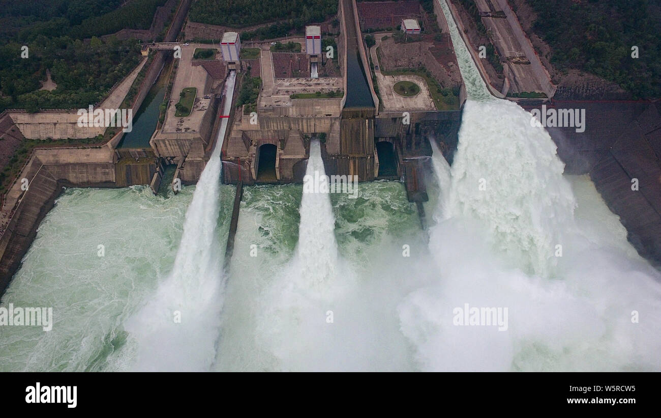 Tourists enjoy water gushing out from the Xiaolangdi Dam for flood ...
