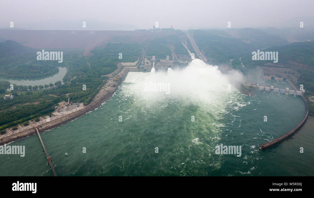 Tourists enjoy water gushing out from the Xiaolangdi Dam for flood ...