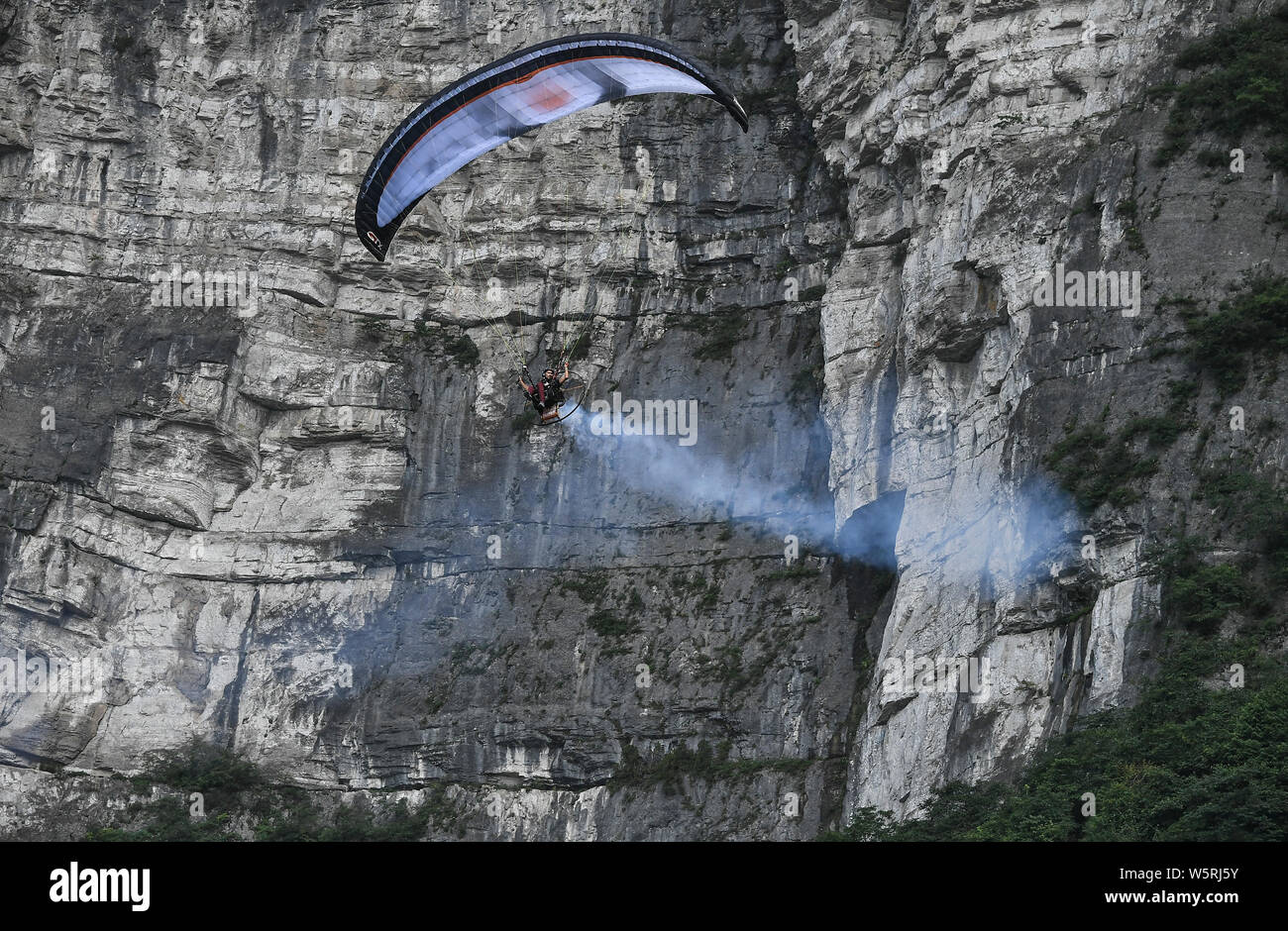 A wingsuit flyer jumps from a high place to glide through the air ...