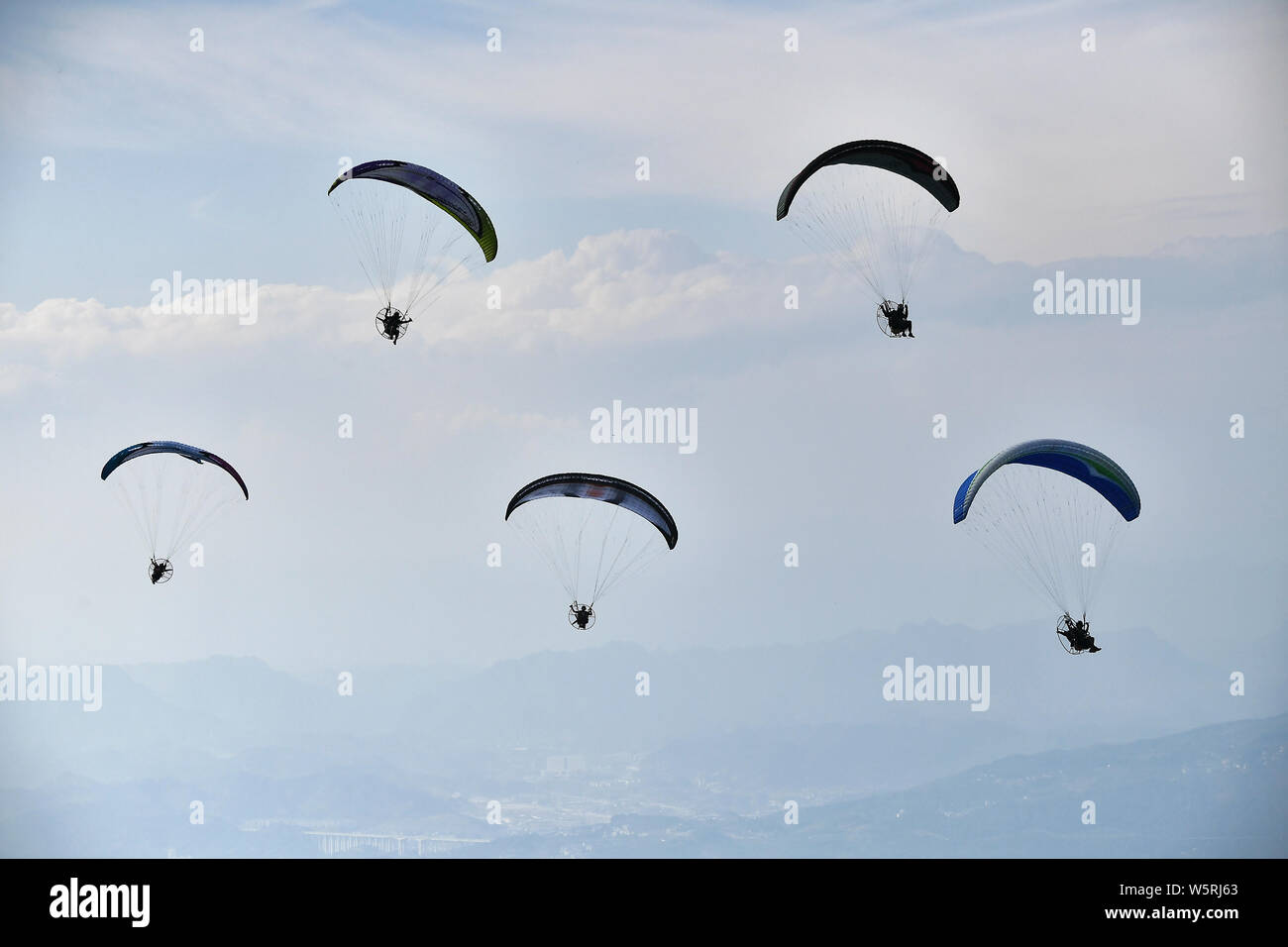 A wingsuit flyer jumps from a high place to glide through the air ...