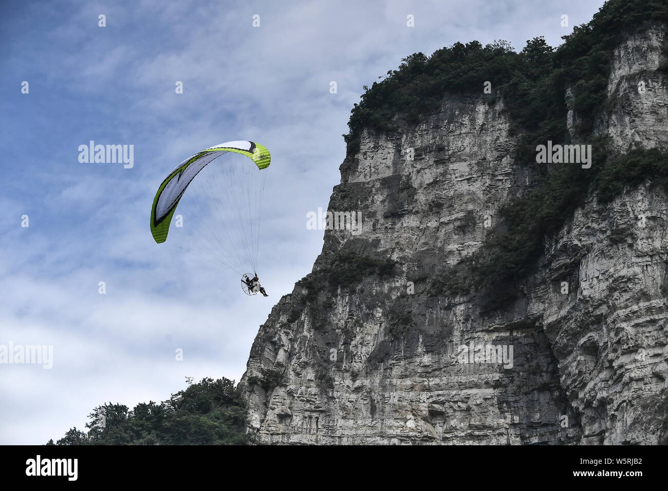 A wingsuit flyer jumps from a high place to glide through the air ...