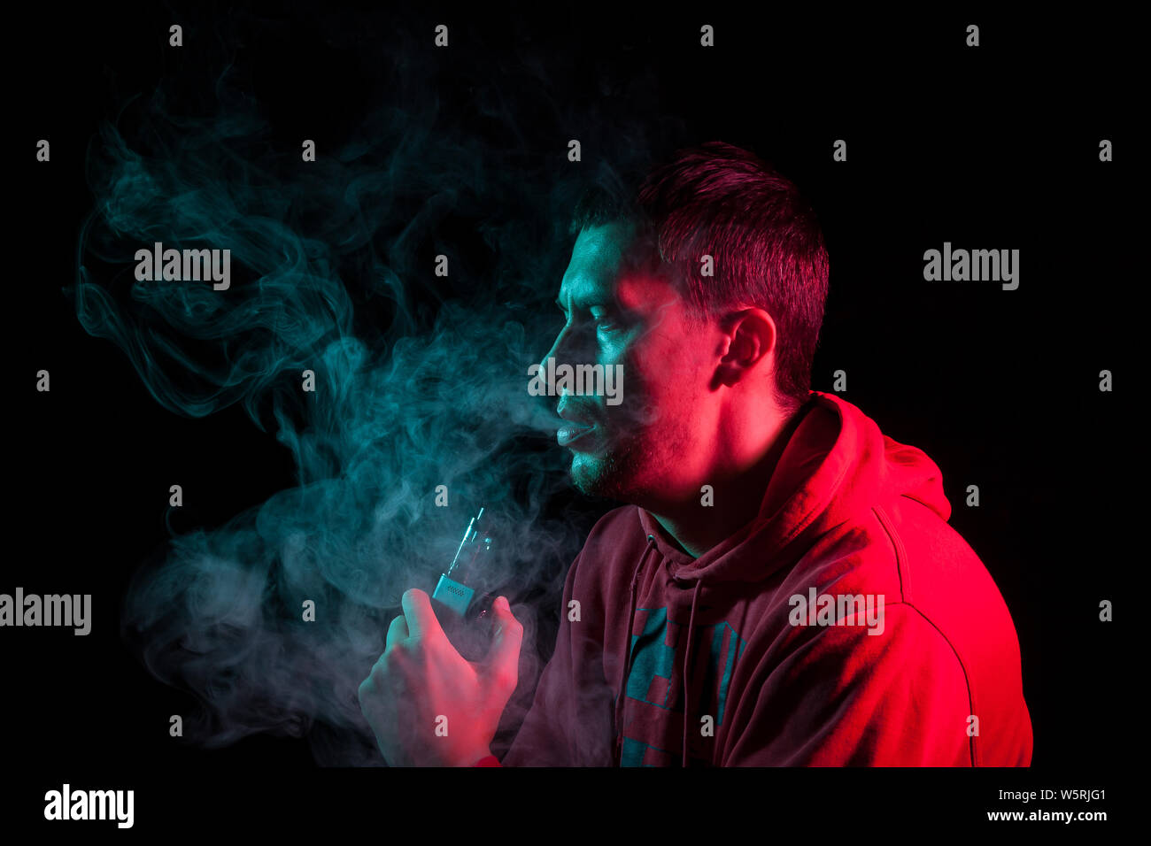 Close up portrait of the face of an adult serious man exhales green ...