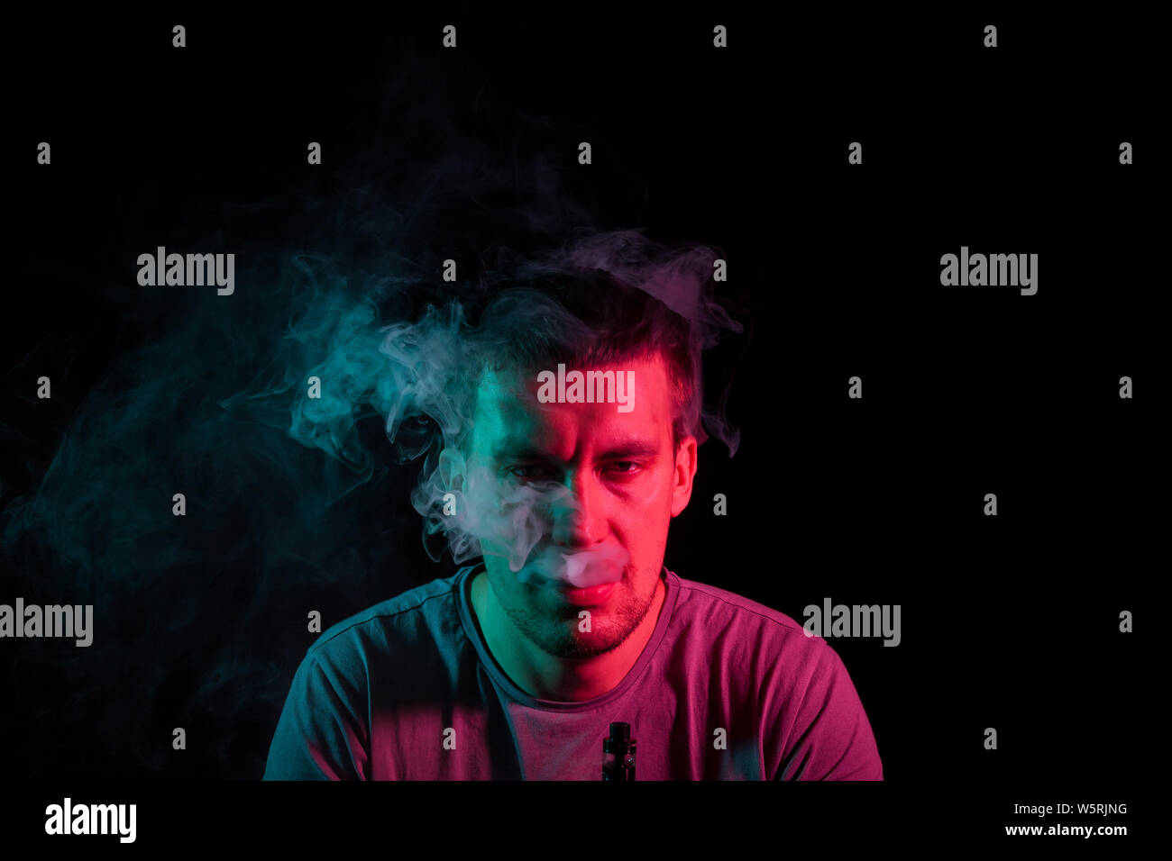 Close up portrait of the face of an adult serious man exhales green ...