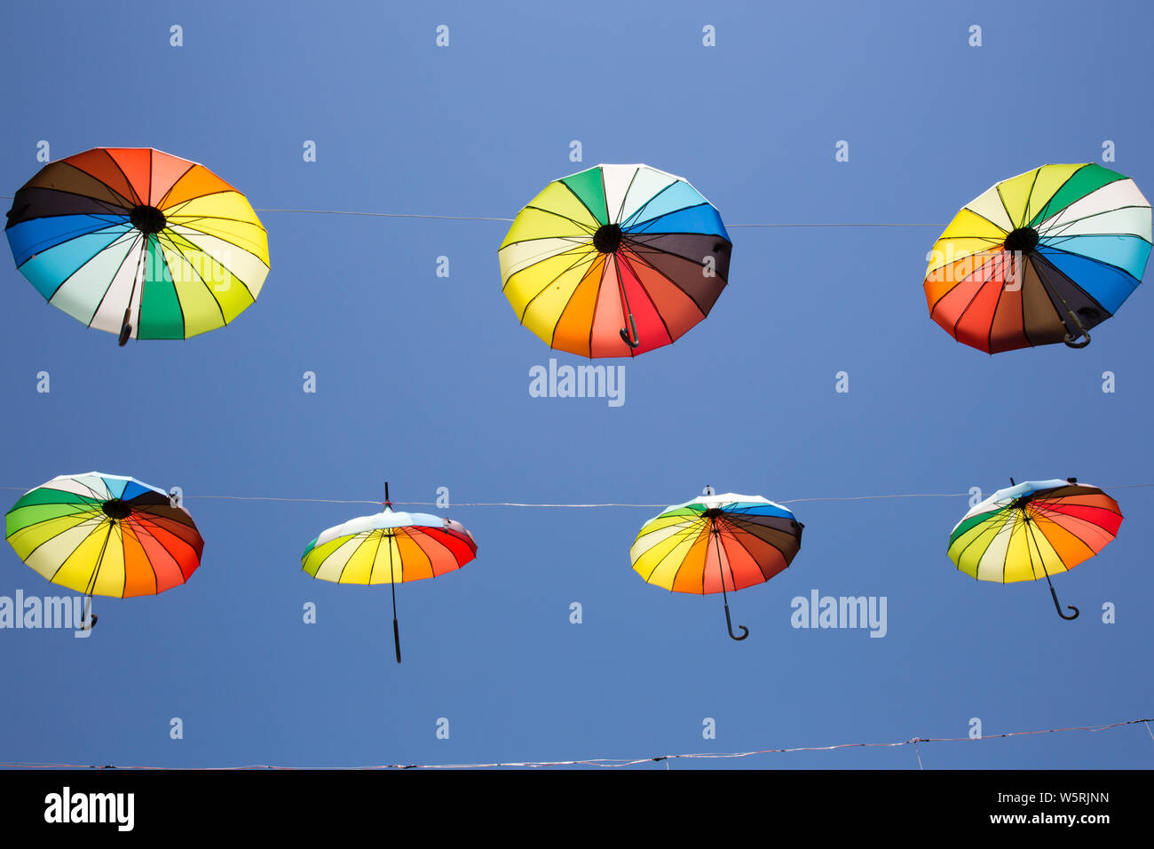 Colorful brollies suspended by wires over a street in Icmeler, Mugla ...
