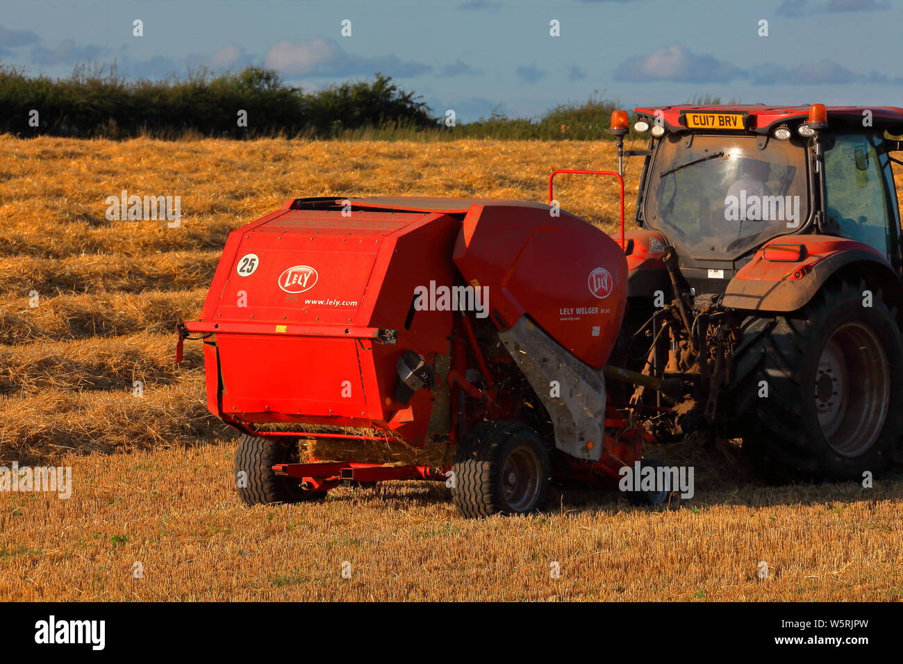A modern straw compactor collecting the straw and rolling it into huge ...