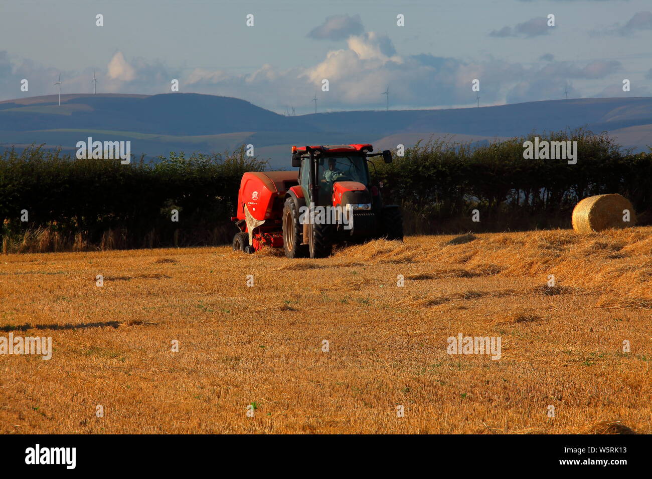 A modern straw compactor collecting the straw and rolling it into huge ...