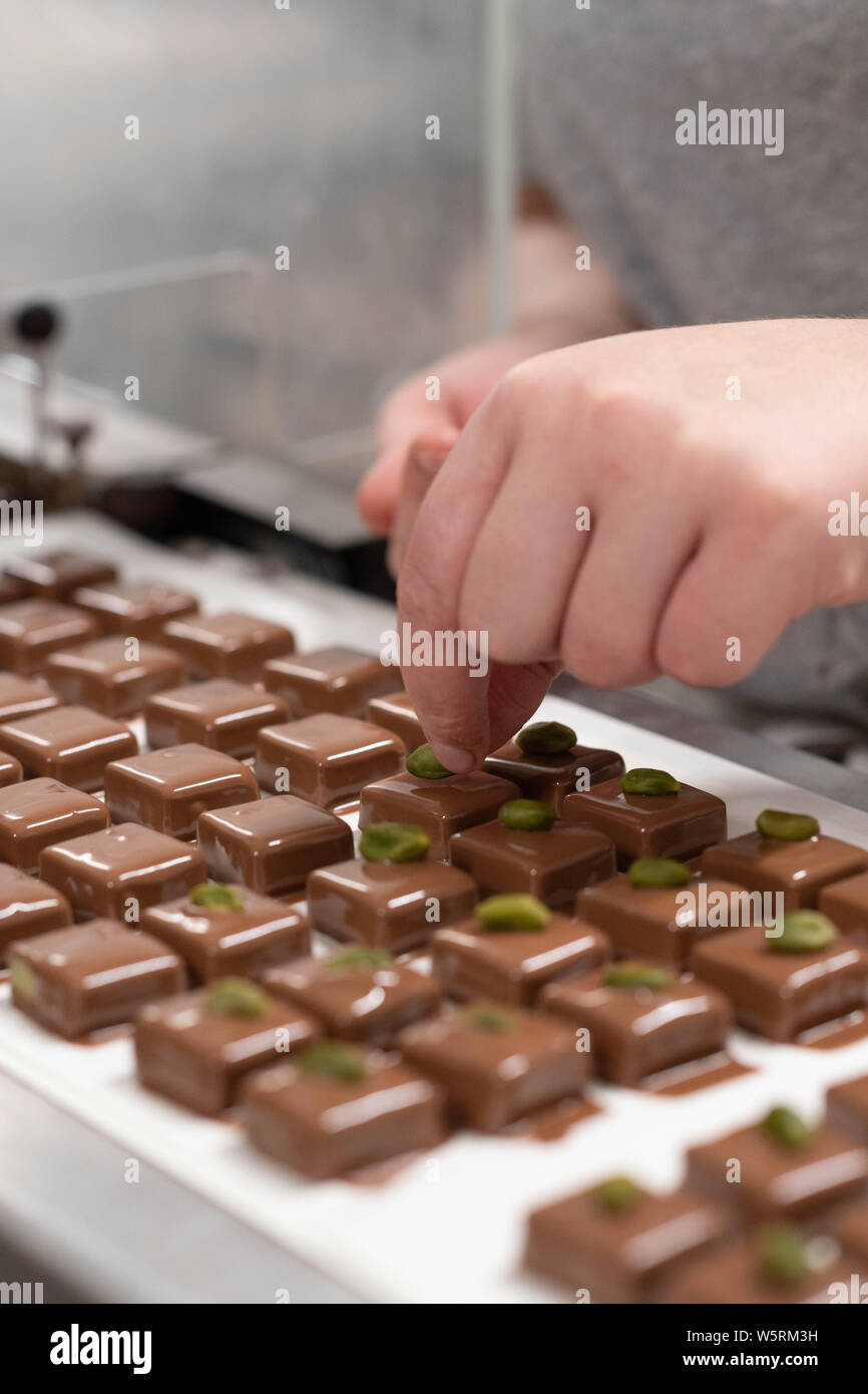 Making of chocolate in Pierre Lionneton Chocolate factory. Hand putting ...