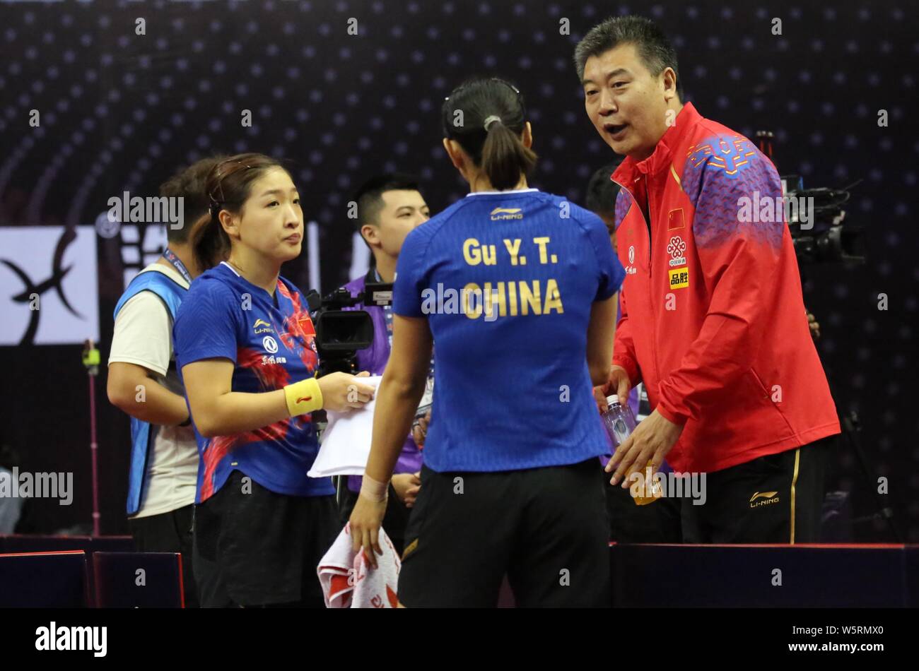 Gu Yuting and Liu Shiwen of China talk to their coach as they compete ...