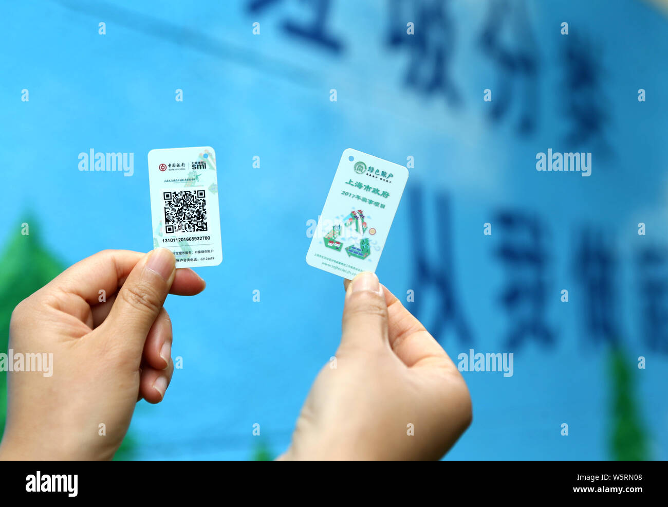 Local residents shows QR code cards used to open different bins to put ...