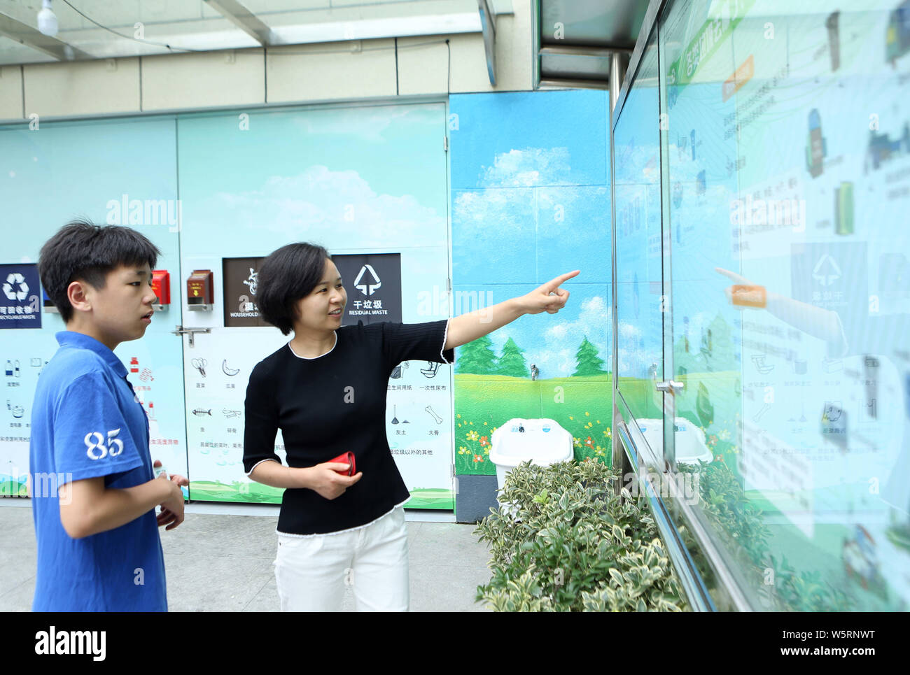 Local residents use QR code cards to open different bins to put their ...