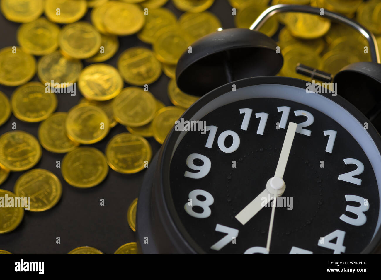Alarm clock and coins stacks on working table, time for savings money ...