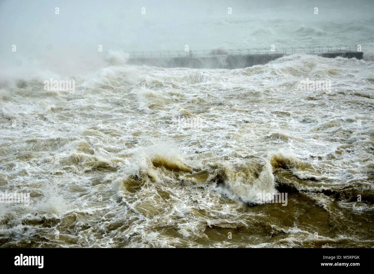 Tourists enjoy water gushing out from the Xiaolangdi Dam during a silt ...