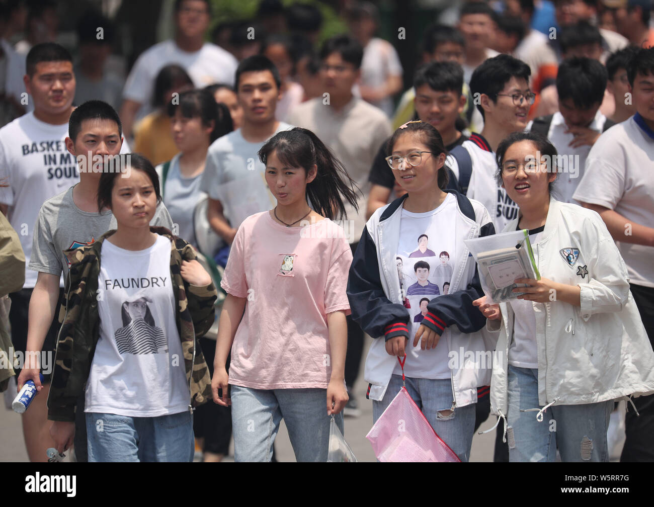 A crowd of young Chinese student examinees walk out from a middle ...